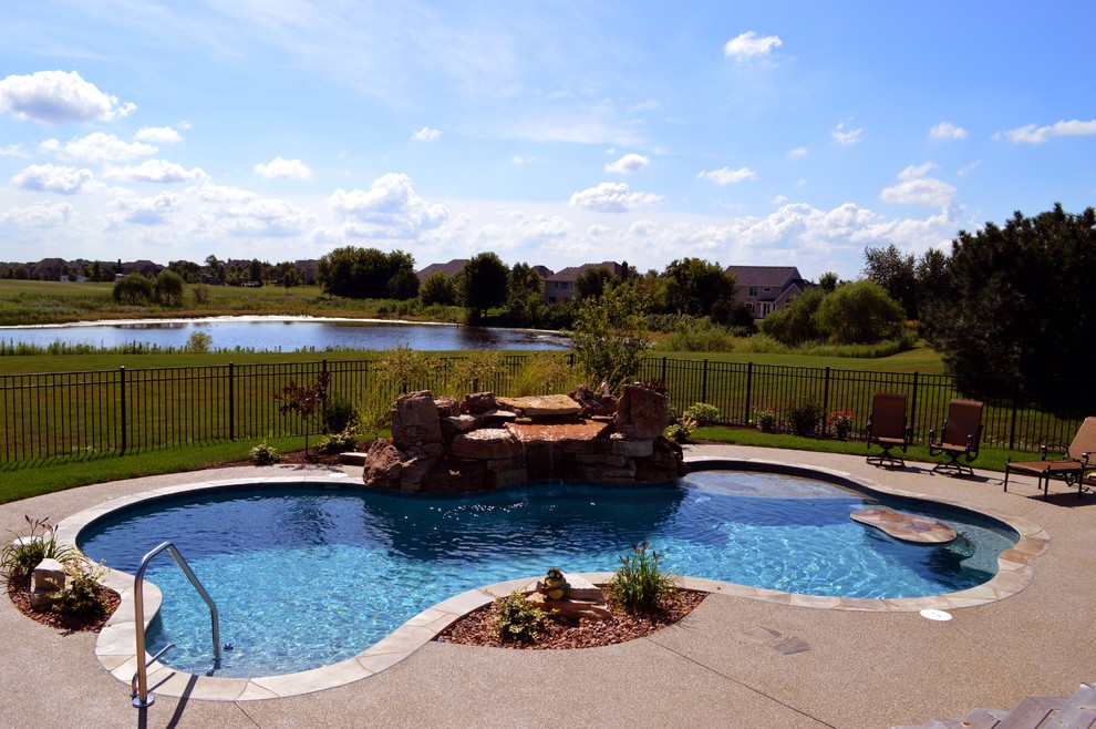 Free form pool with stone table, sun shelf, water feature, and outdoor ...