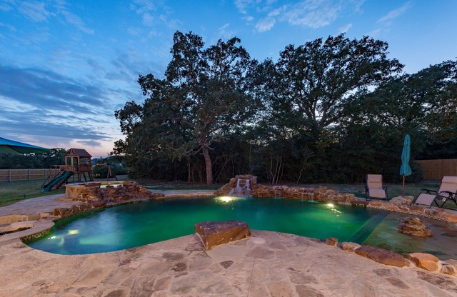 Rustic lagoon style pool with a fire pit, water falls and a hot tub ...